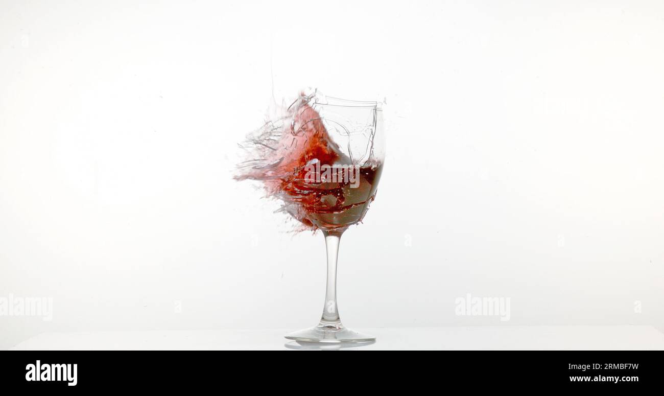 Glass of Red Wine Breaking and Splashing against White Background Stock ...