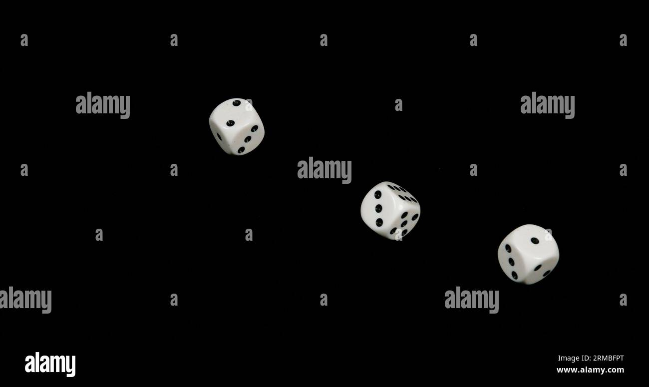 Dice rolling against Black background Stock Photo - Alamy