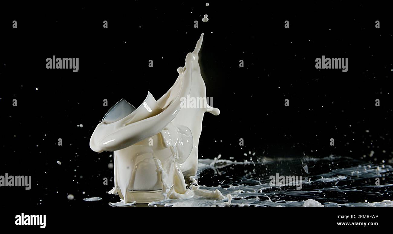 Glass of Milk Exploding against White Background Stock Photo - Alamy