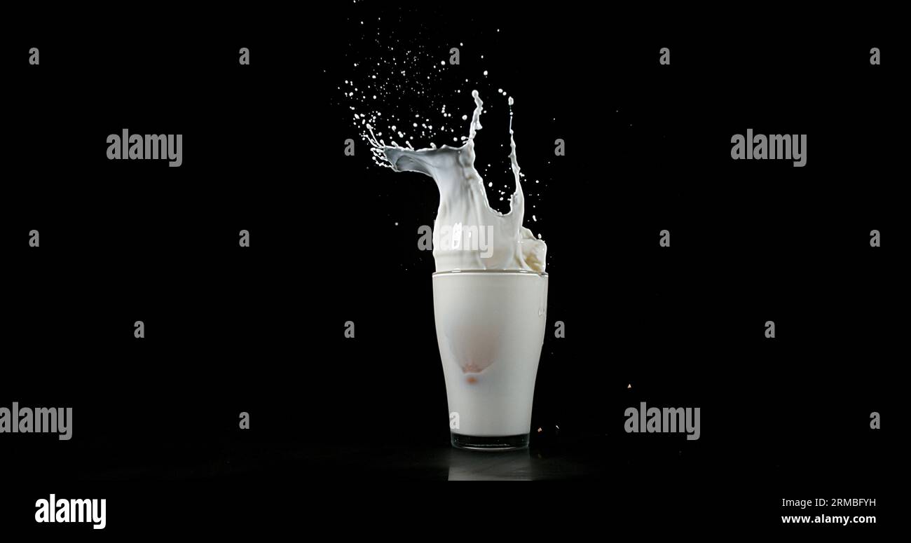 Glass of Milk Exploding against White Background Stock Photo - Alamy