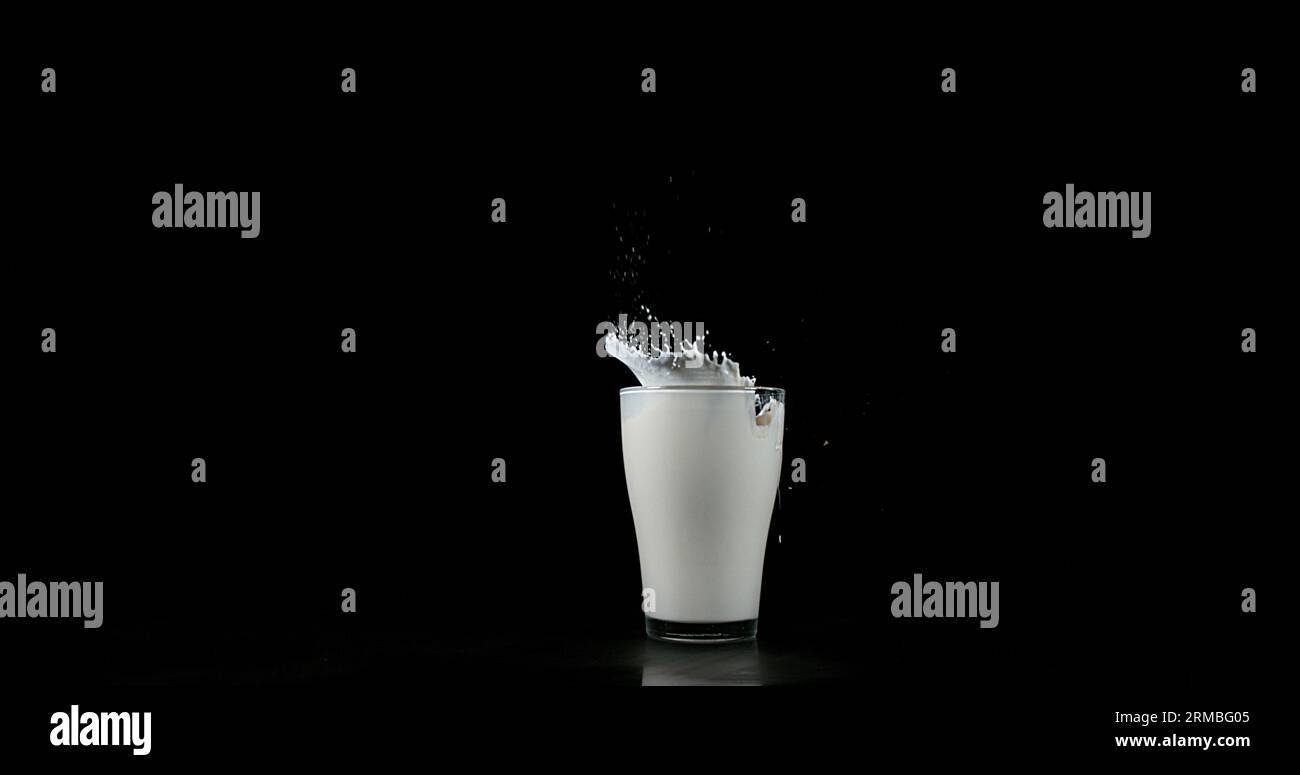 Glass of Milk Exploding against White Background Stock Photo - Alamy