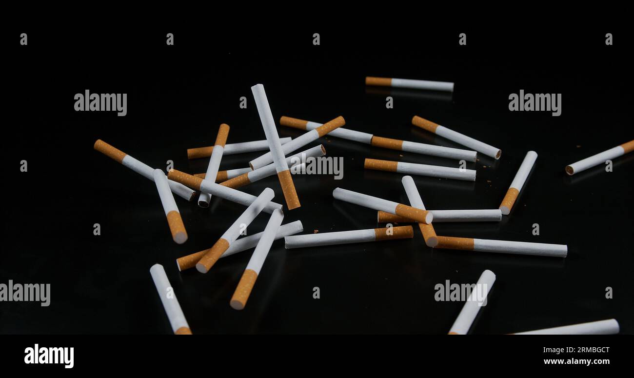 Cigarettes Falling against Black Background Stock Photo - Alamy