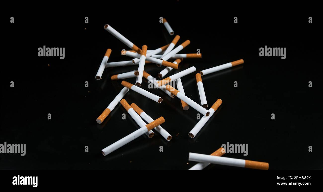 Cigarettes Falling against Black Background Stock Photo - Alamy