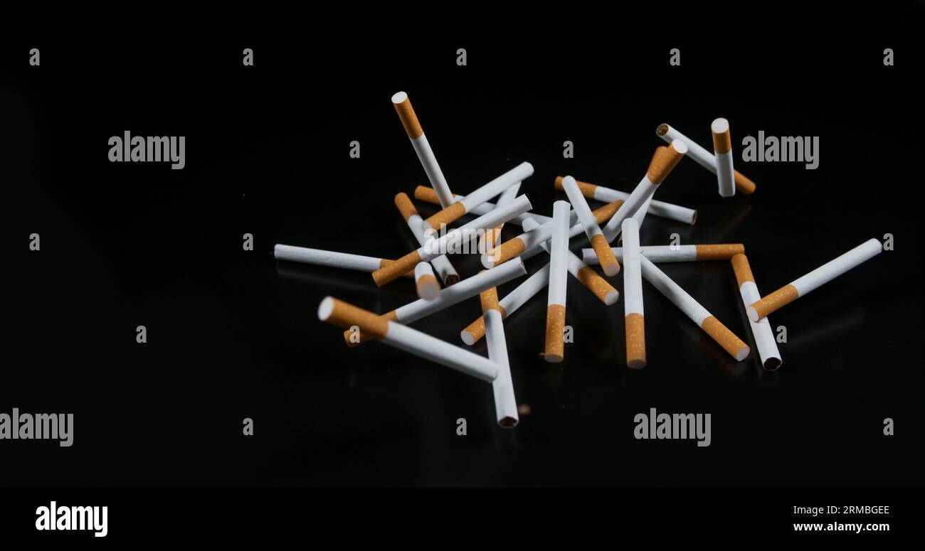 Cigarettes Falling against Black Background Stock Photo - Alamy