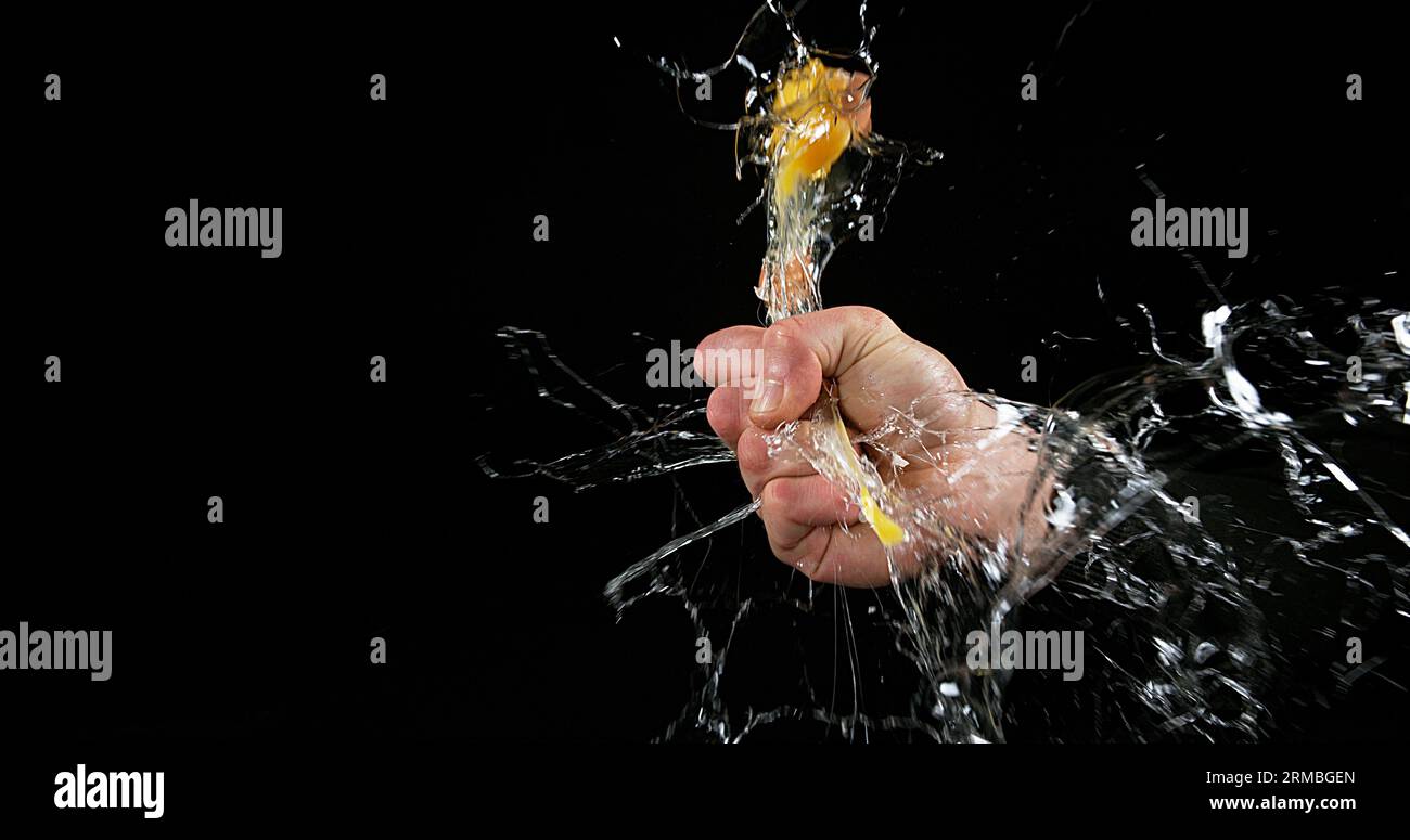 Hand of Man Breaking a Chicken Egg against Black Background Stock Photo ...