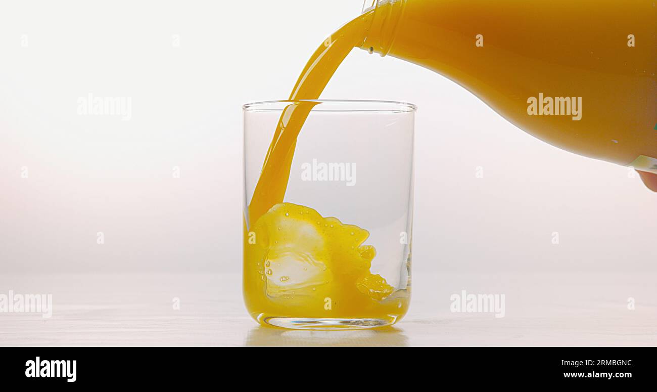 Orange Juice being poured into Glass against White Background Stock ...