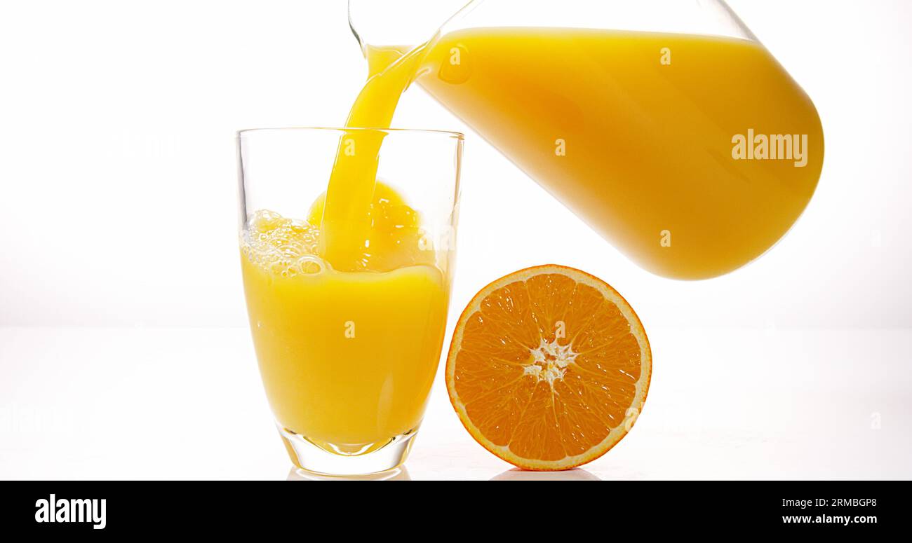 Orange Juice being poured into Glass against White Background Stock ...
