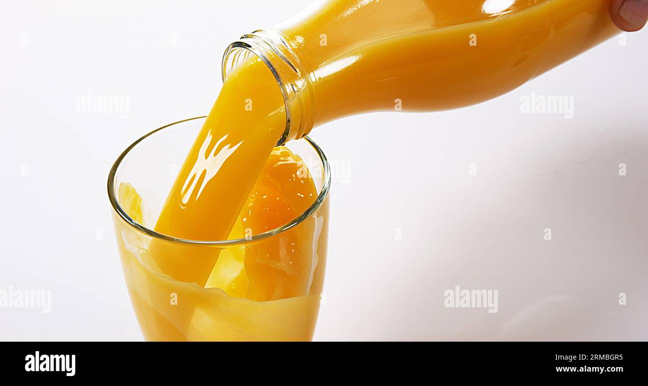 Orange Juice being poured into Glass against White Background Stock ...