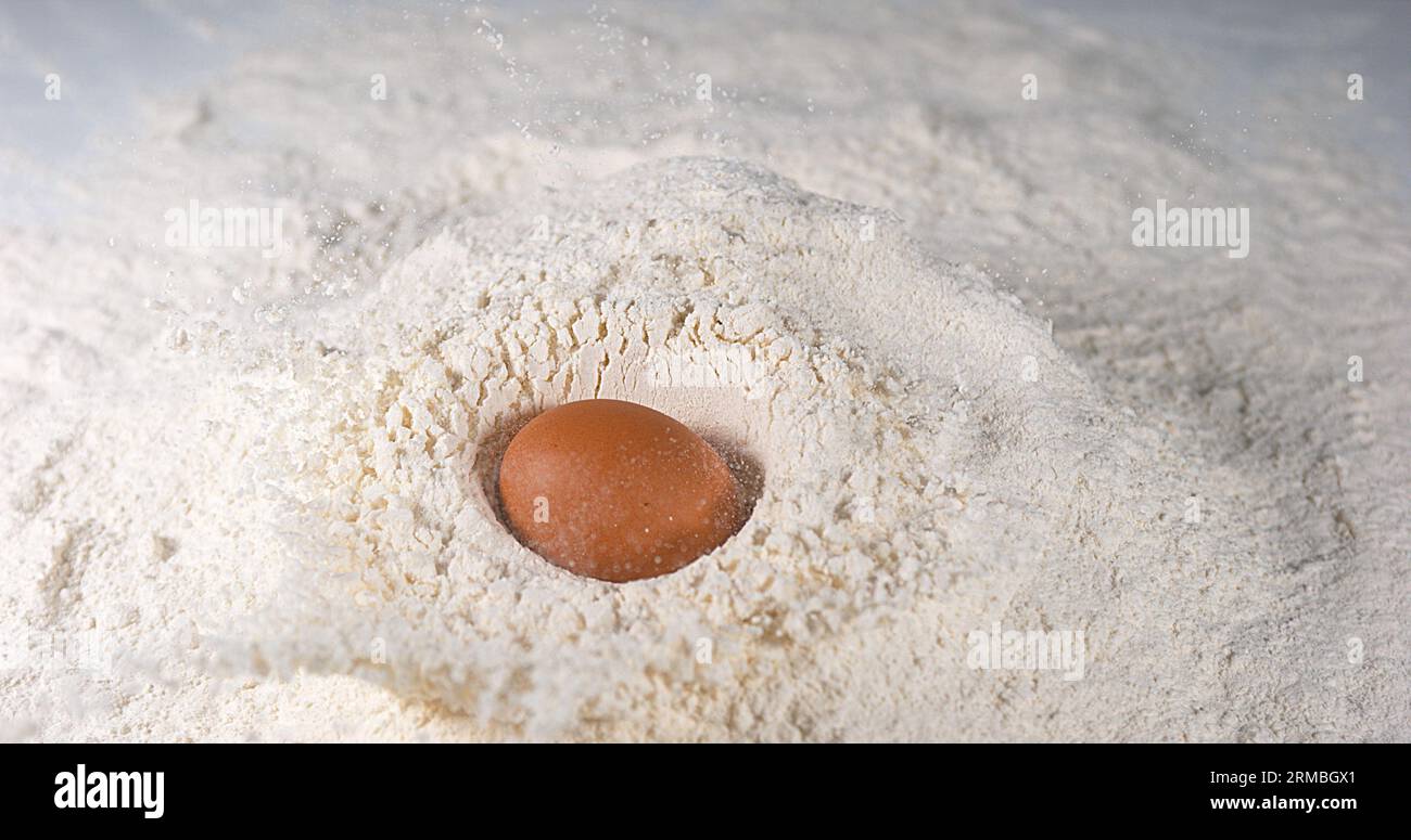 Egg Falling on Flour Stock Photo - Alamy