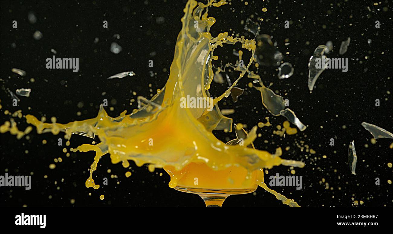 Glass of Orange Exploding against Black Background Stock Photo - Alamy