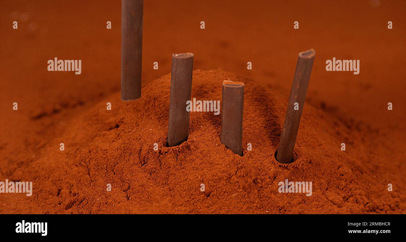Chocolate Bars falling on Black Chocolate Powder Stock Photo - Alamy