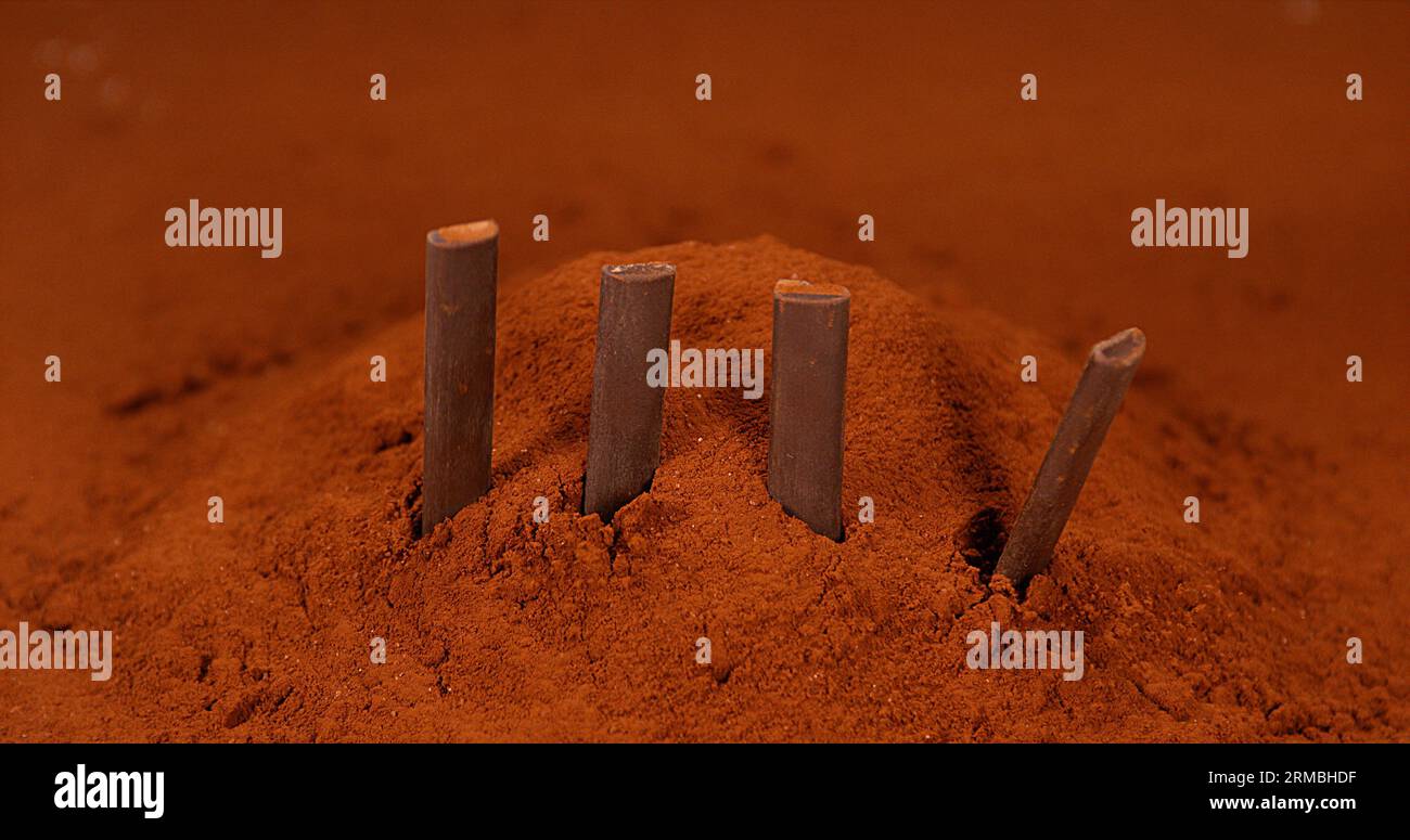 Chocolate Bars falling on Black Chocolate Powder Stock Photo - Alamy