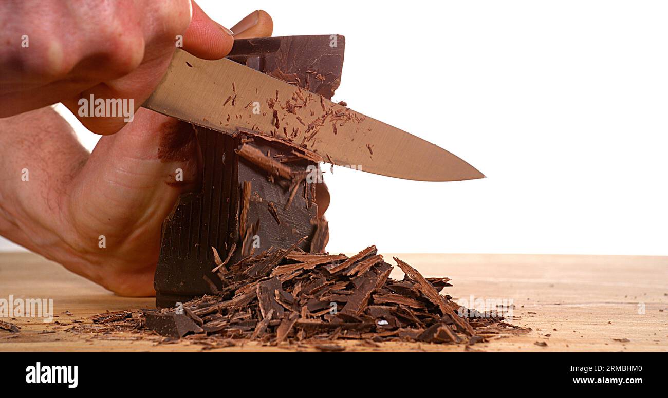 Man Cutting Black Chocolate with Knife Stock Photo - Alamy