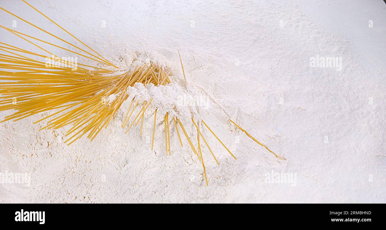 Pasta falling on flour against White Background Stock Photo - Alamy