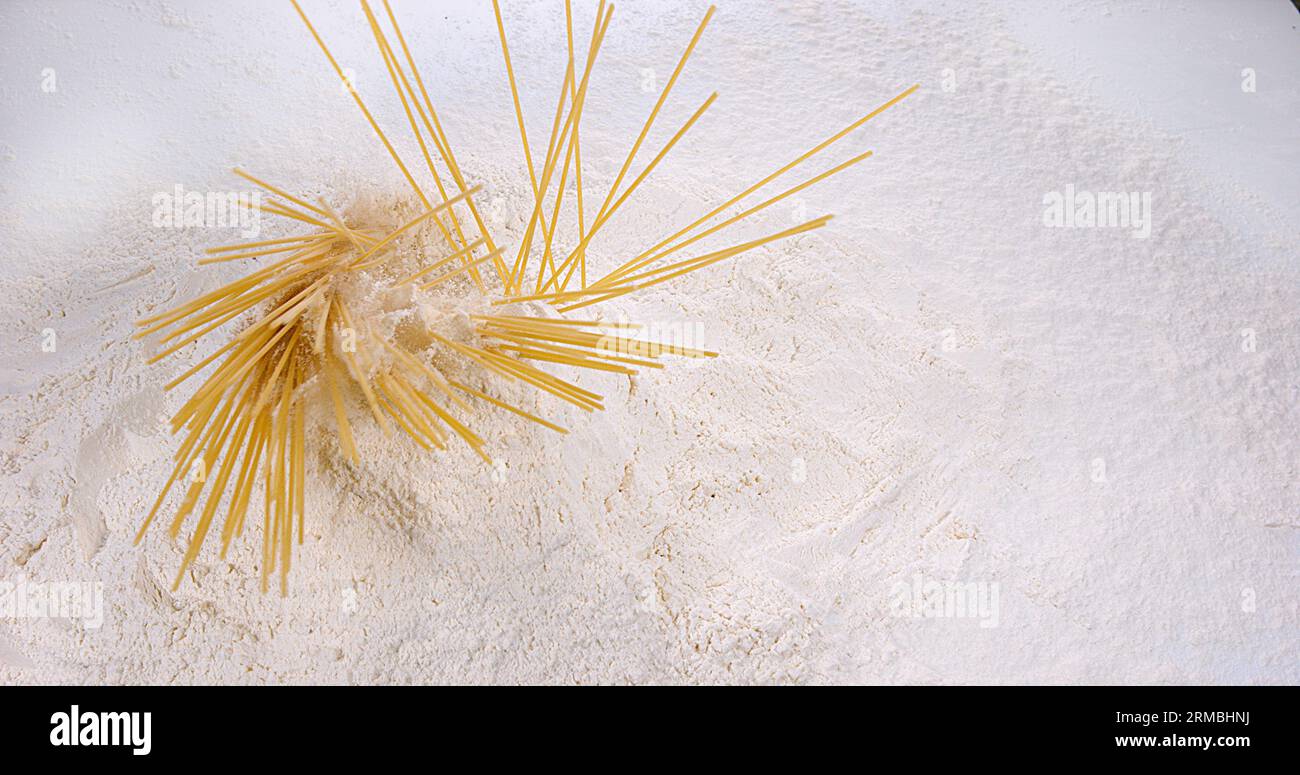 Pasta falling on flour against White Background Stock Photo - Alamy