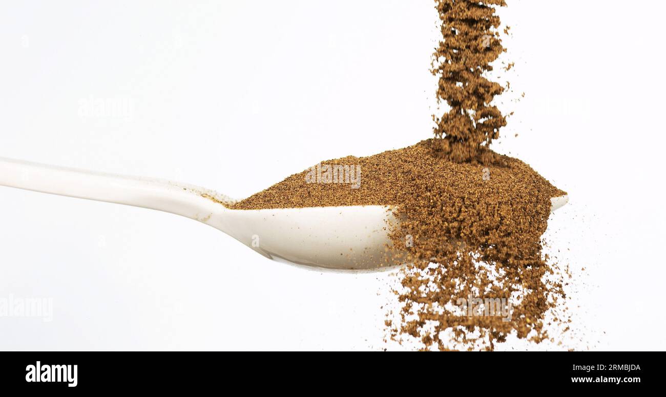 Green pepper, piper nigrum, spice falling on a Spoon against white ...