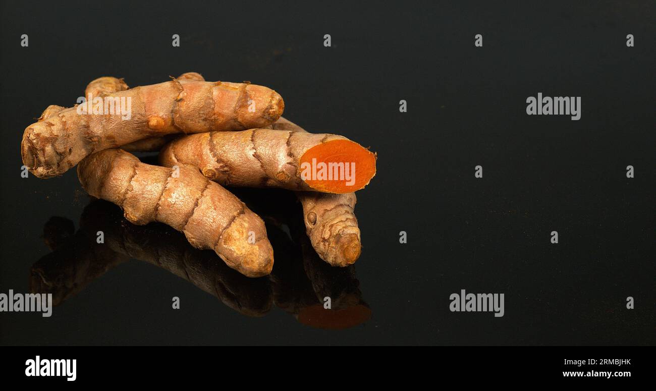 Turmeric, curcuma longa, Roots falling against Black Background, Indian ...