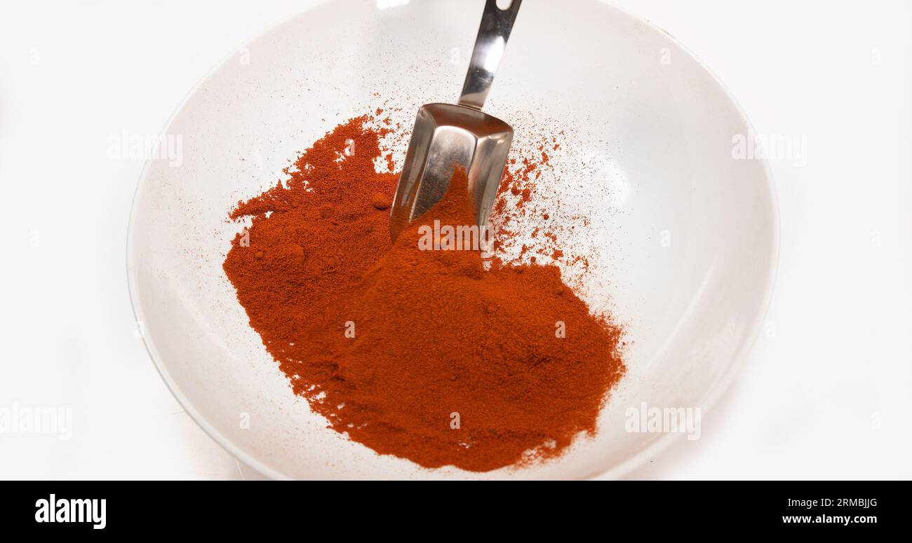 Paprika, capsicum annuum, Powder falling into a Bowl against White ...