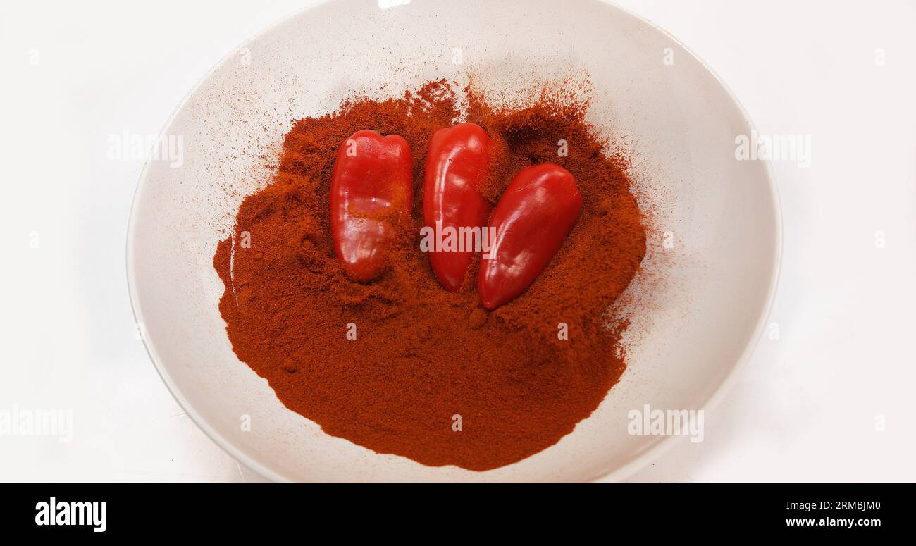 Paprika, capsicum annuum, falling into a bowl against White Background ...
