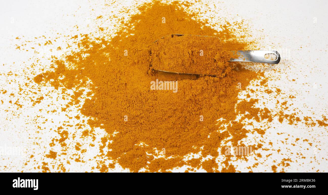 Curry Powder falling against white background Stock Photo - Alamy