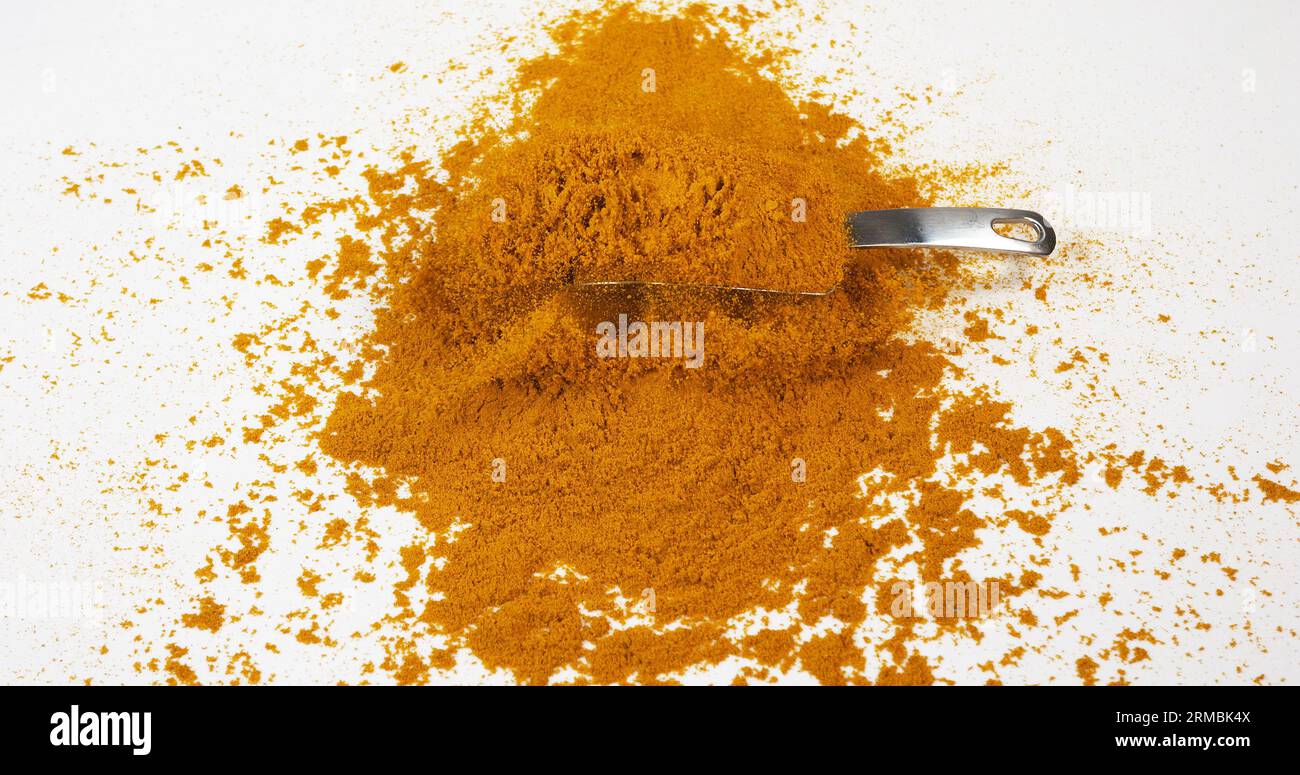 Curry Powder falling against white background Stock Photo - Alamy