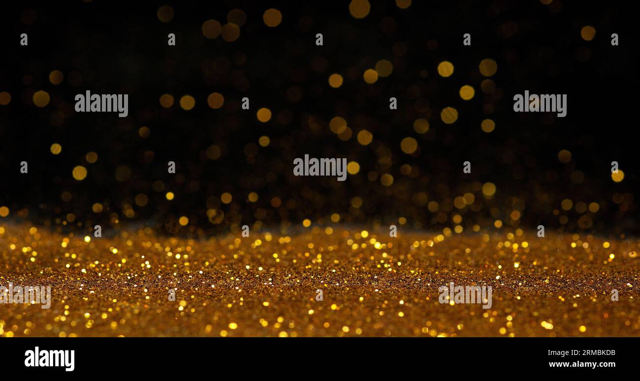 Gold Powder falling against Black Background Stock Photo - Alamy