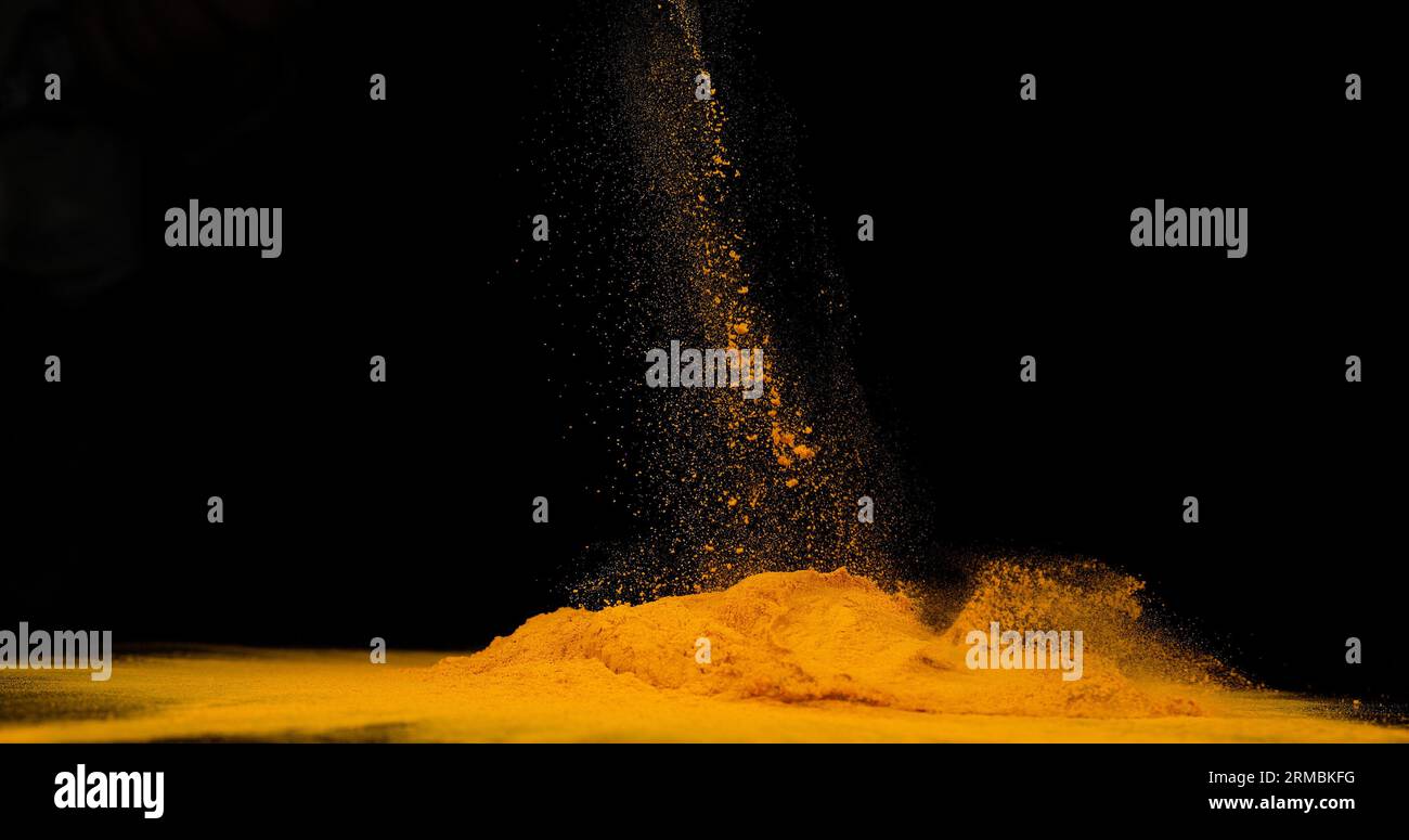 Turmeric, curcuma longa, Powder falling against Black Background ...