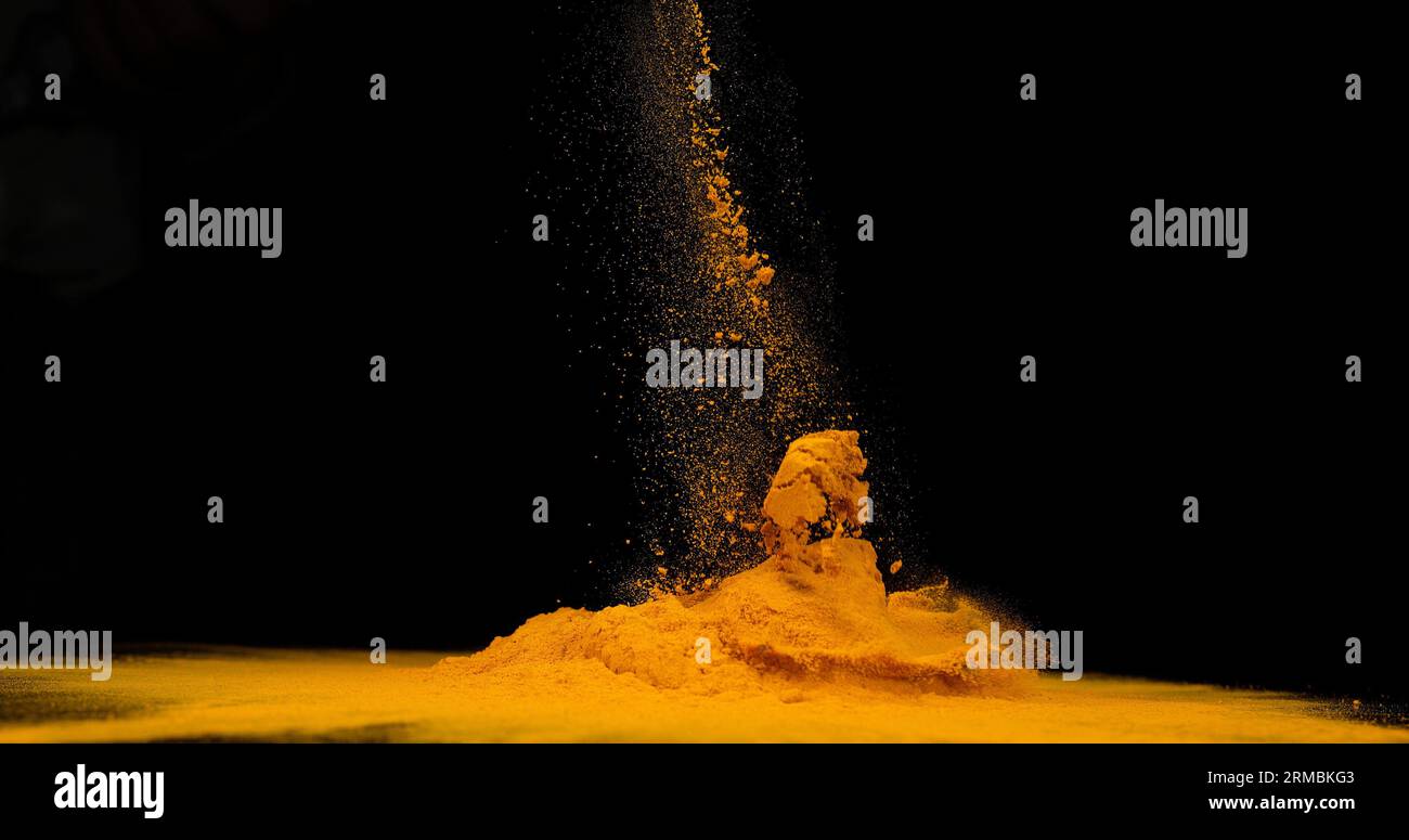 Turmeric, curcuma longa, Powder falling against Black Background ...