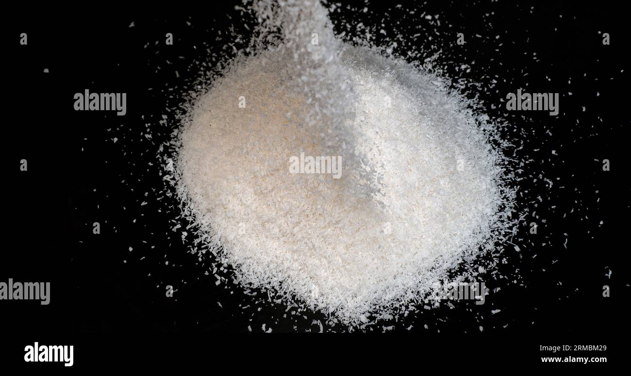 Coconut, cocos nucifera, Powder falling against Black Background Stock ...
