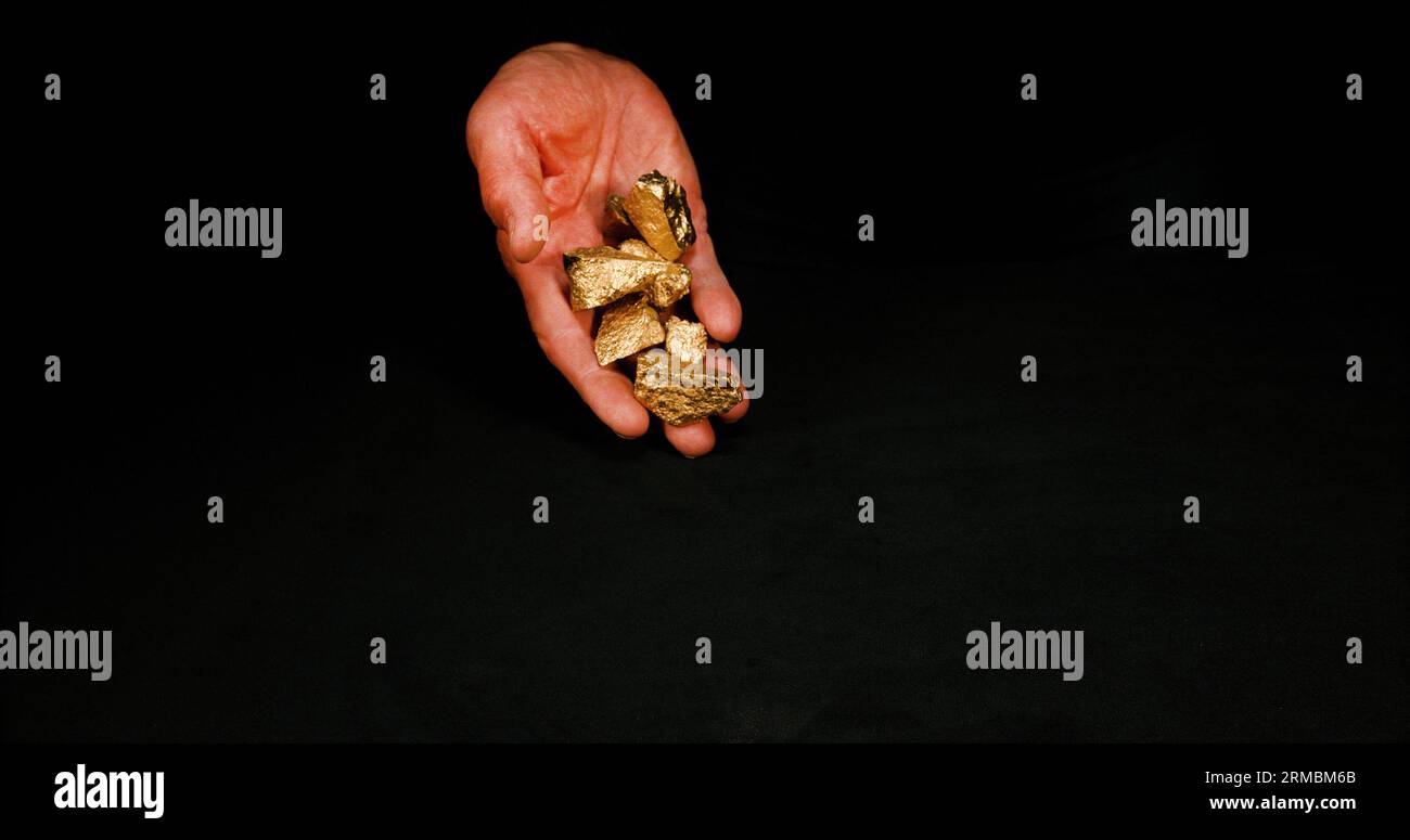 Hand and Gold Nuggets, Nugget, Falling on Black Background Stock Photo ...