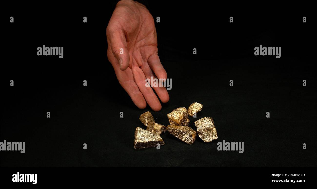 Hand and Gold Nuggets, Nugget, Falling on Black Background Stock Photo ...