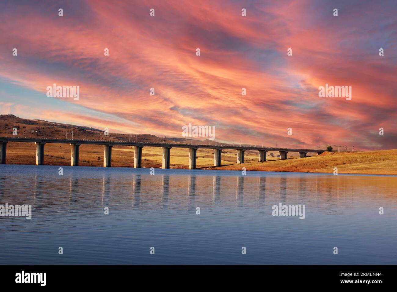 Concrete railroad bridge in the lake. fantastic sunset Stock Photo - Alamy