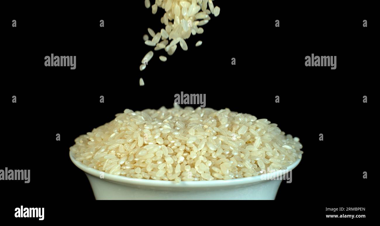 Rice falling against Black Background Stock Photo - Alamy
