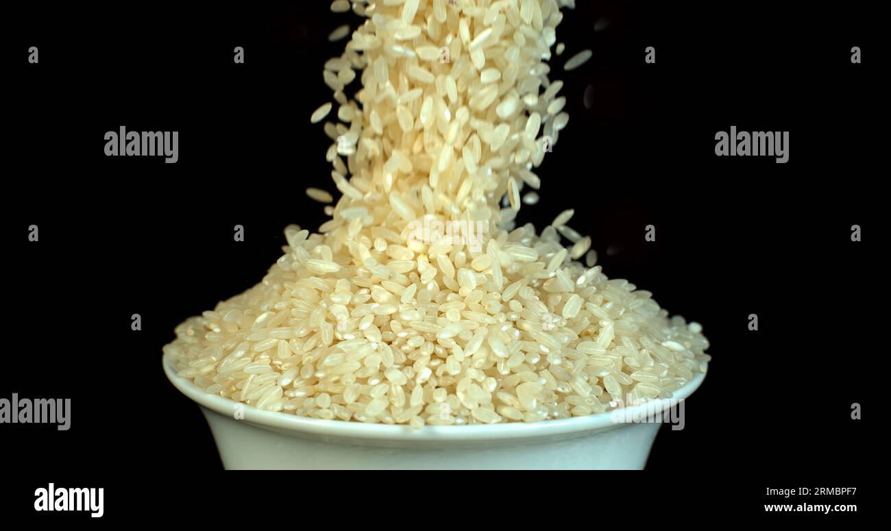 Rice falling against Black Background Stock Photo - Alamy