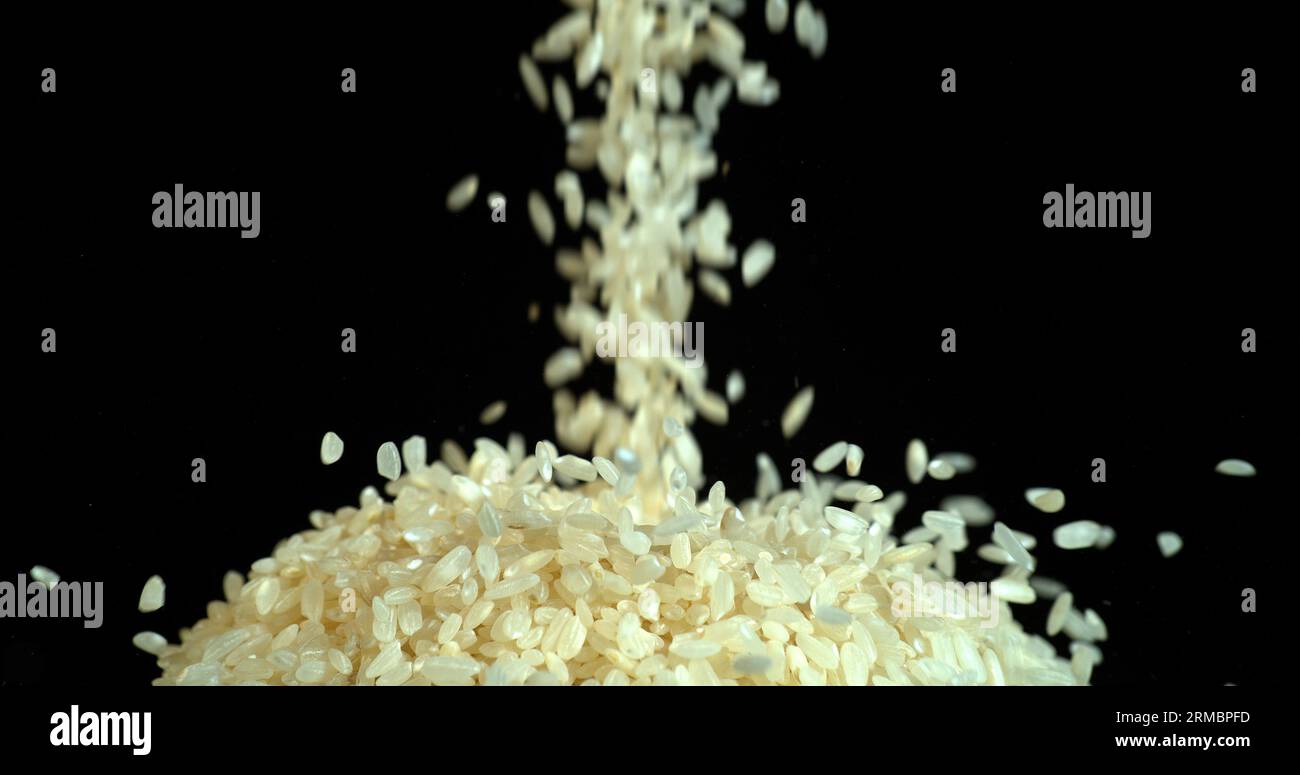 Rice falling against Black Background Stock Photo - Alamy