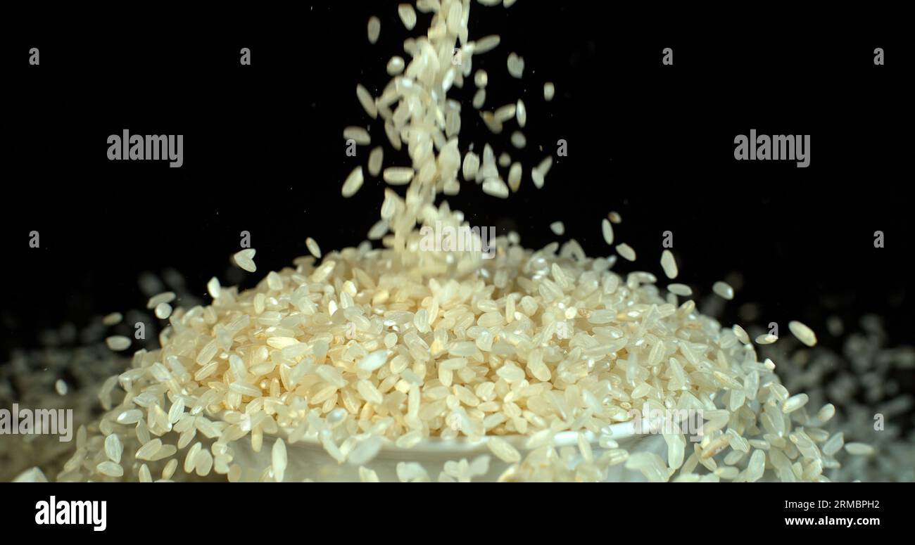 Rice falling against Black Background Stock Photo - Alamy