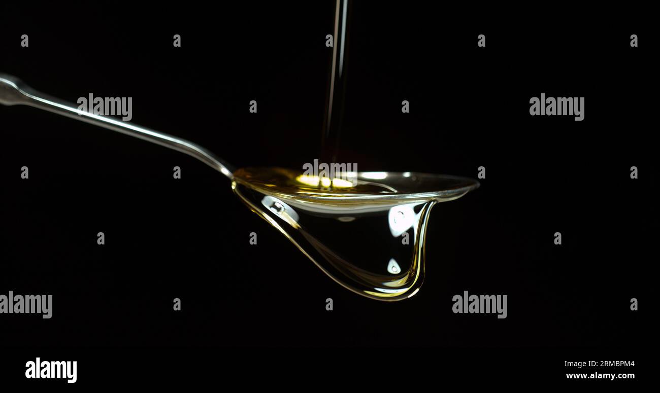 Olive Oil, Falling in a Spoon against Black Background Stock Photo - Alamy