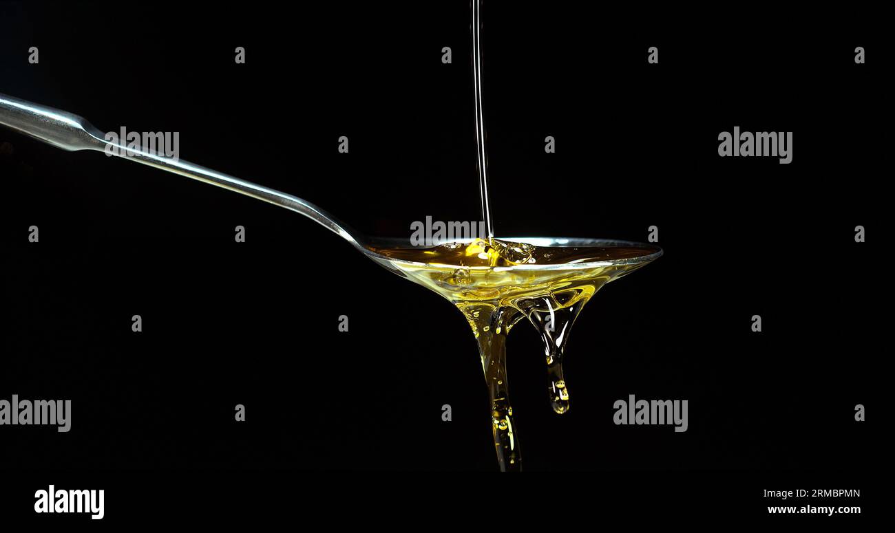 Olive Oil, Falling in a Spoon against Black Background Stock Photo - Alamy