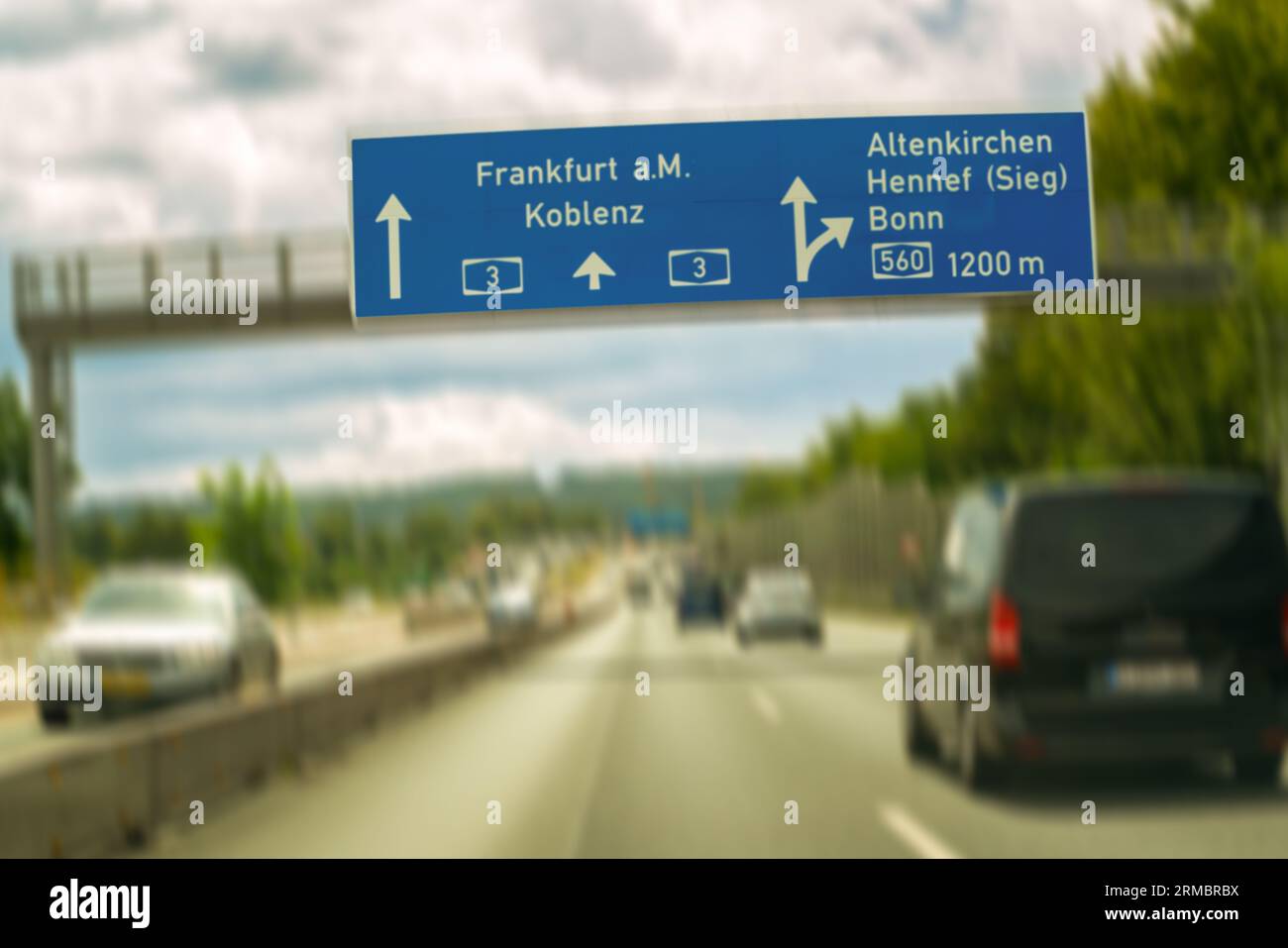 Blue freeway sign over motorway A3 on a rainy day and traffic with ...