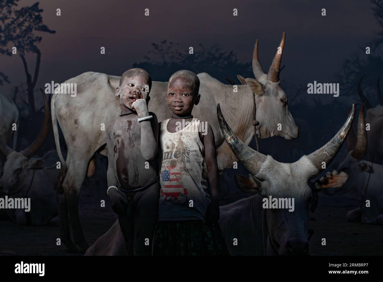 Mundari children with cows in Mundari camp at night Stock Photo - Alamy