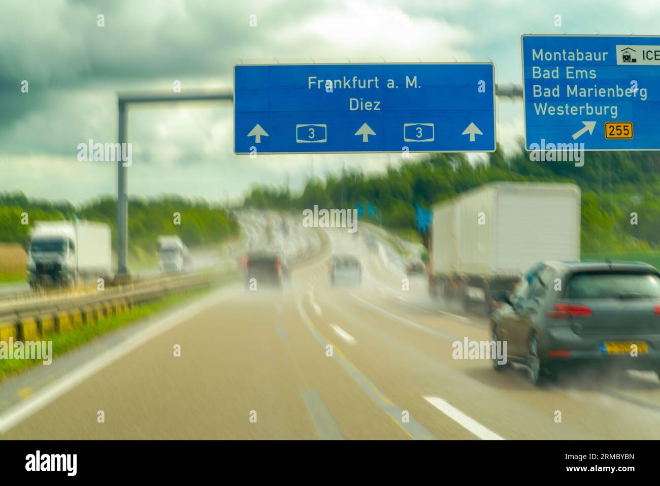 Blue freeway sign over motorway A3 on a rainy day and traffic with ...