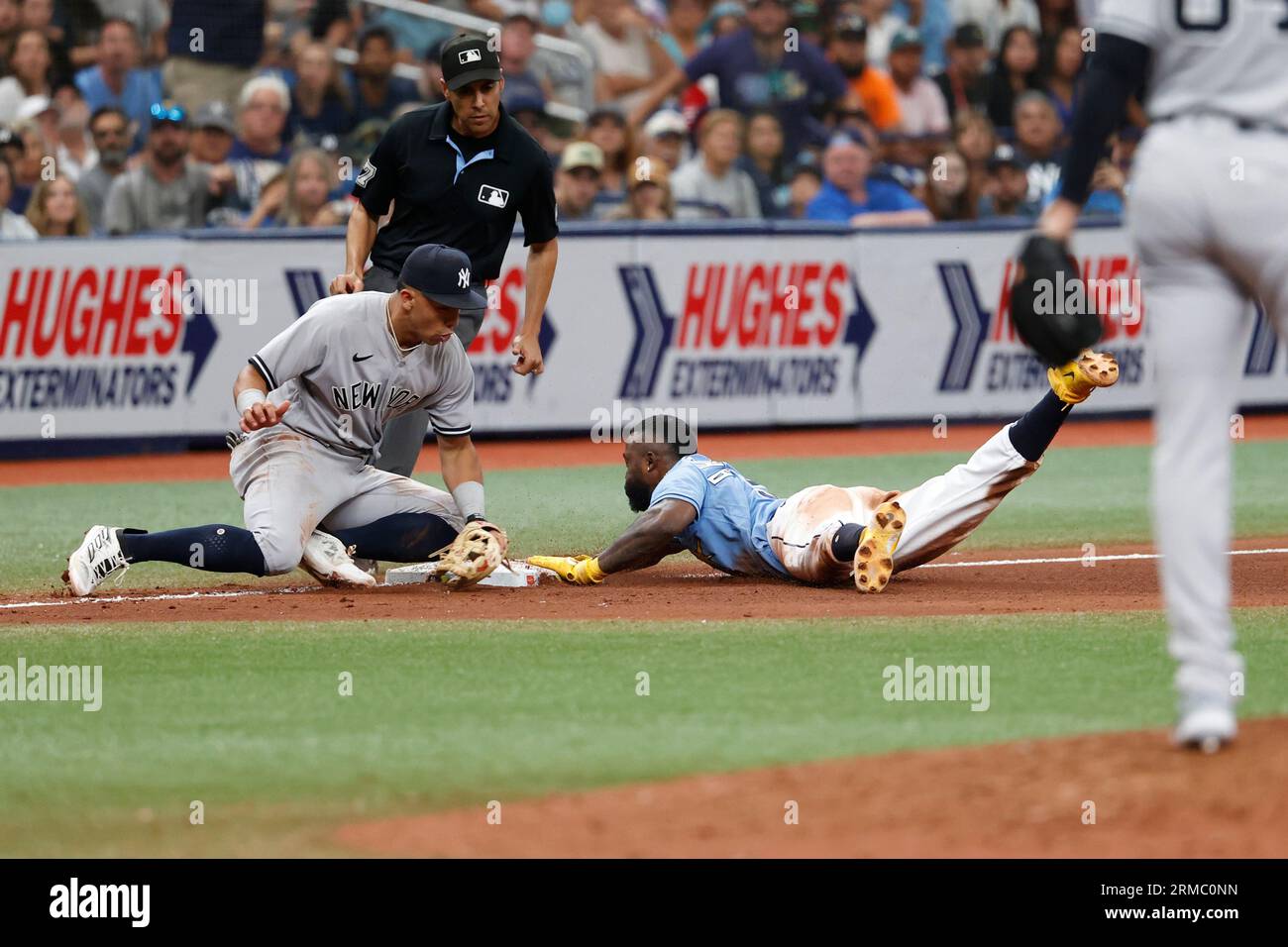 Tampa Bay Rays' Randy Arozarena, center, steals third base beating the ...
