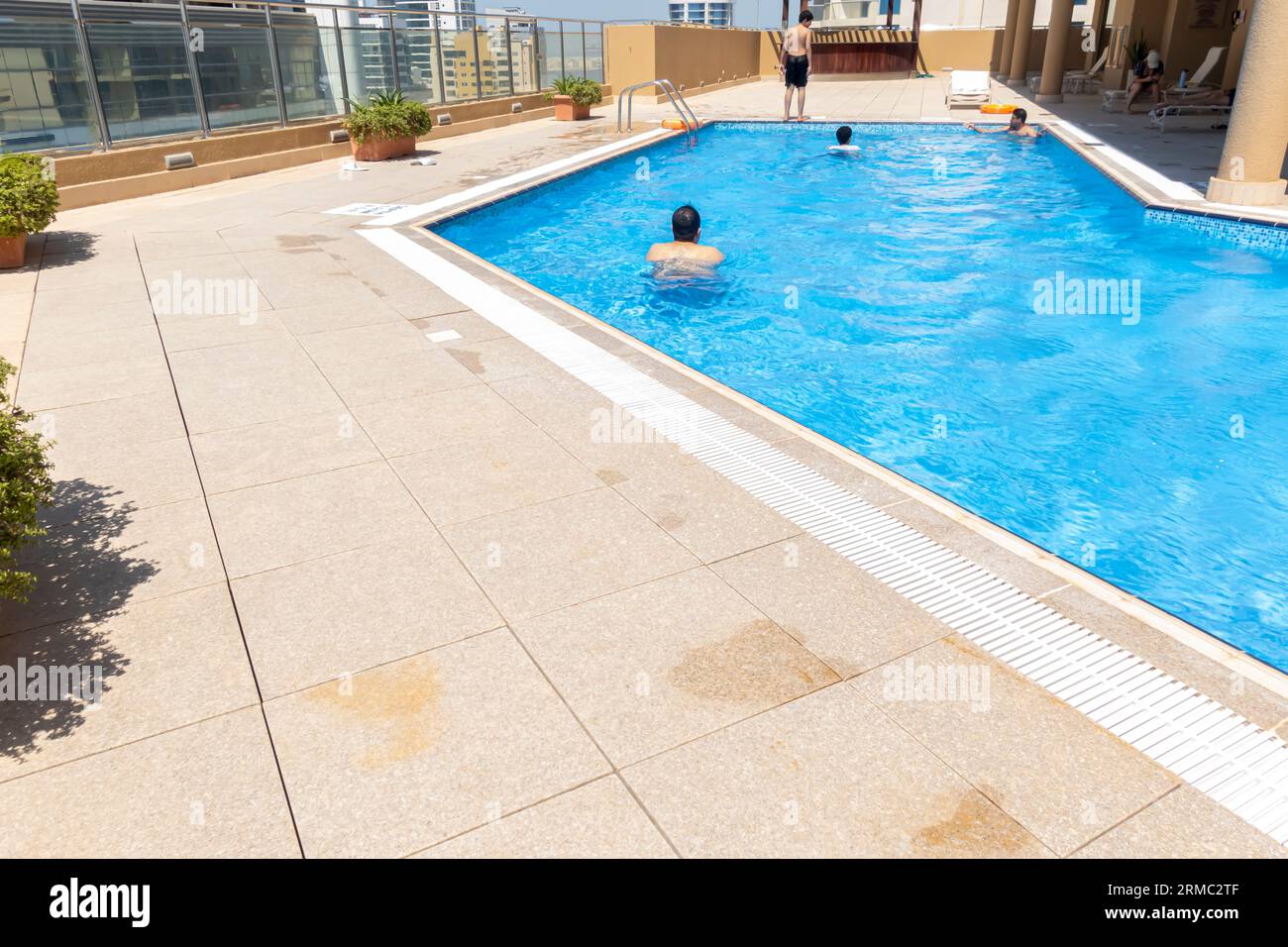 Rooftop pool, people swimming in small roof pool with cityscape view ...