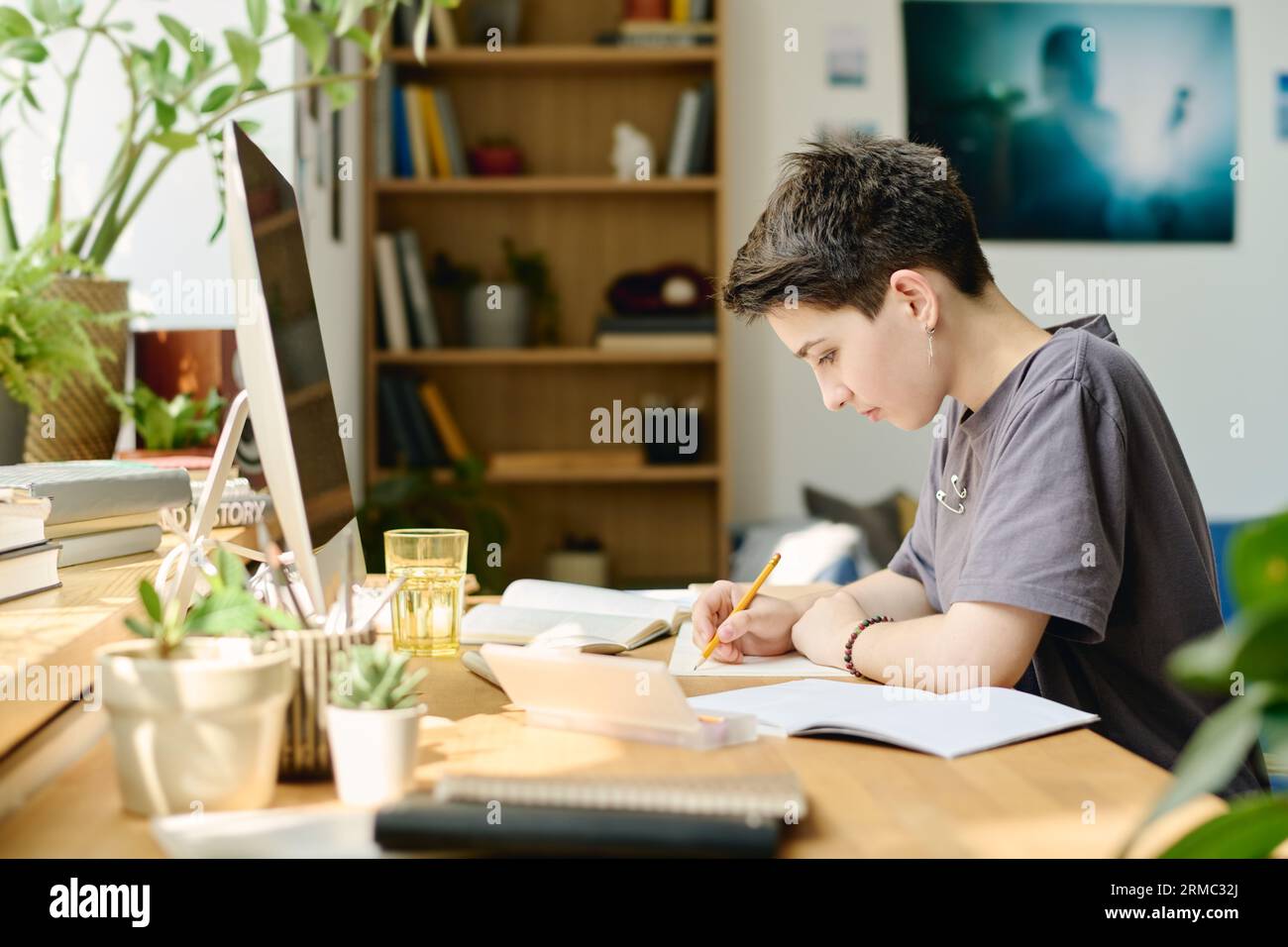 Side view of brunette teenage girl with pencil drawing sketch or making ...