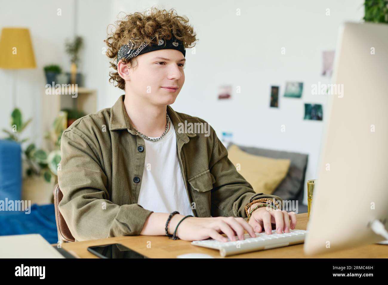 Youthful guy in casualwear looking through information on screen of ...