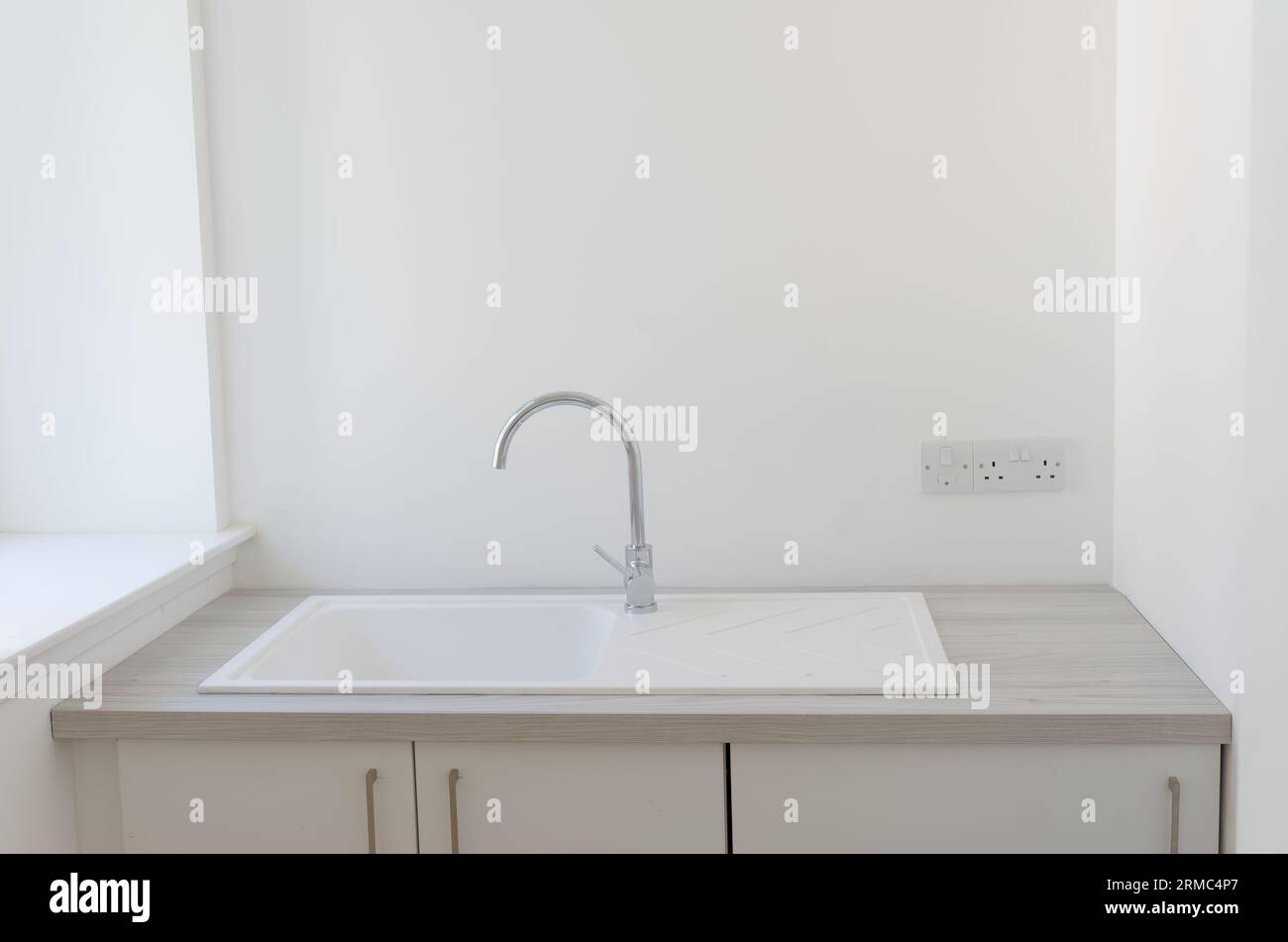 White basin with chrome mixer tap on vanity unit Stock Photo - Alamy