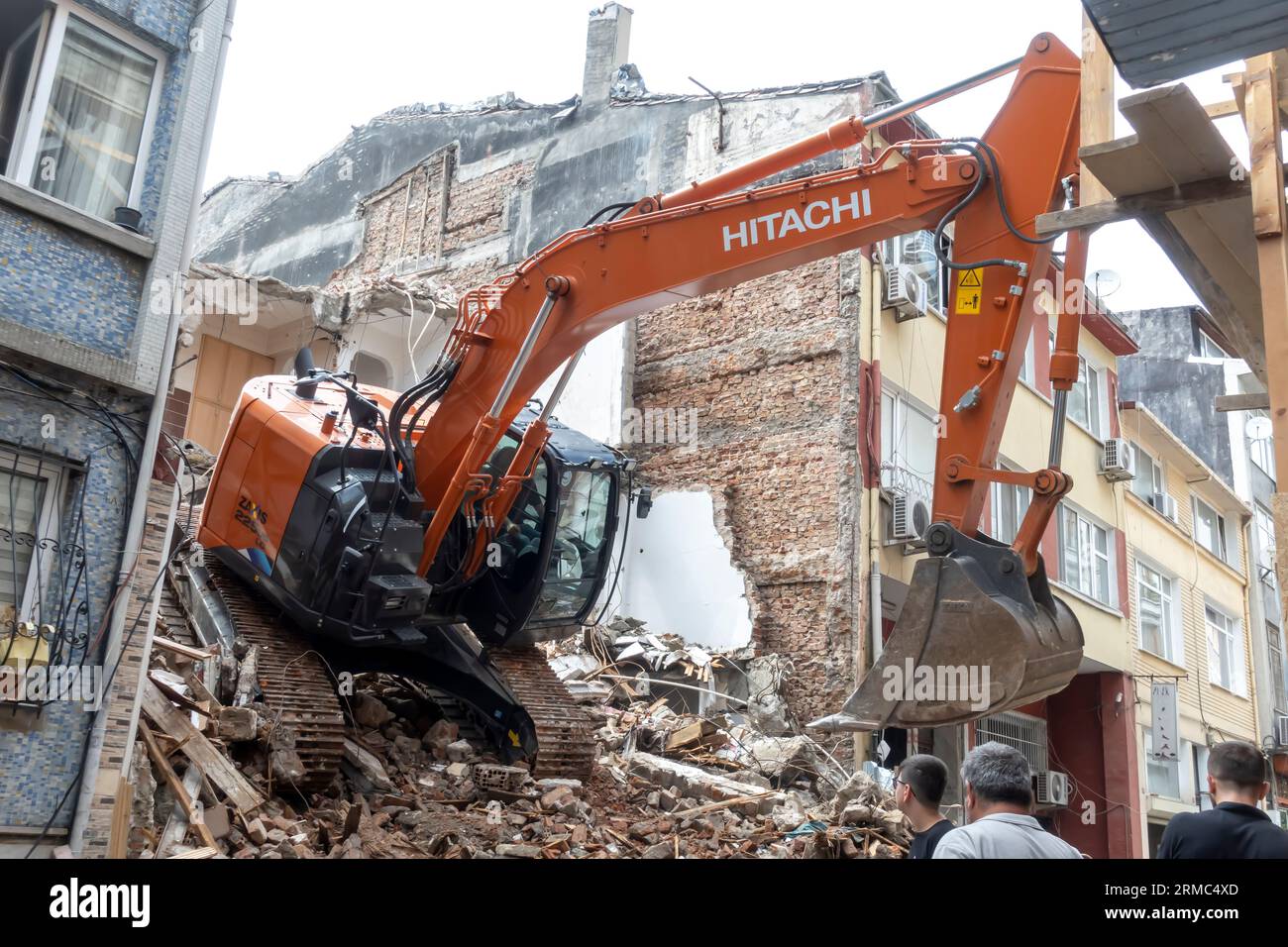 Hitachi Construction Excavator demolishing a building in a narrow ...