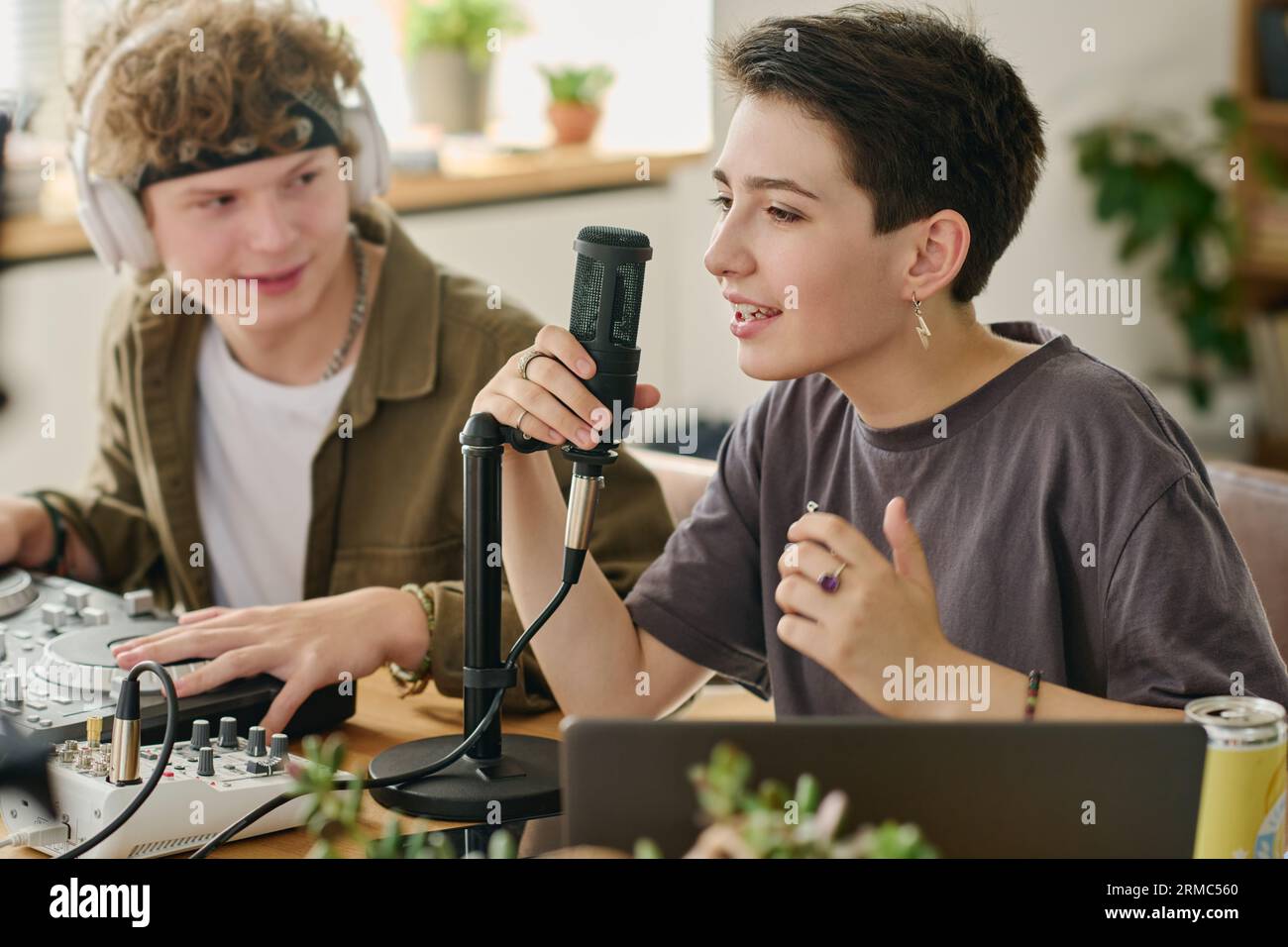 Cute teenage girl sing in microphone during broadcast from home while ...
