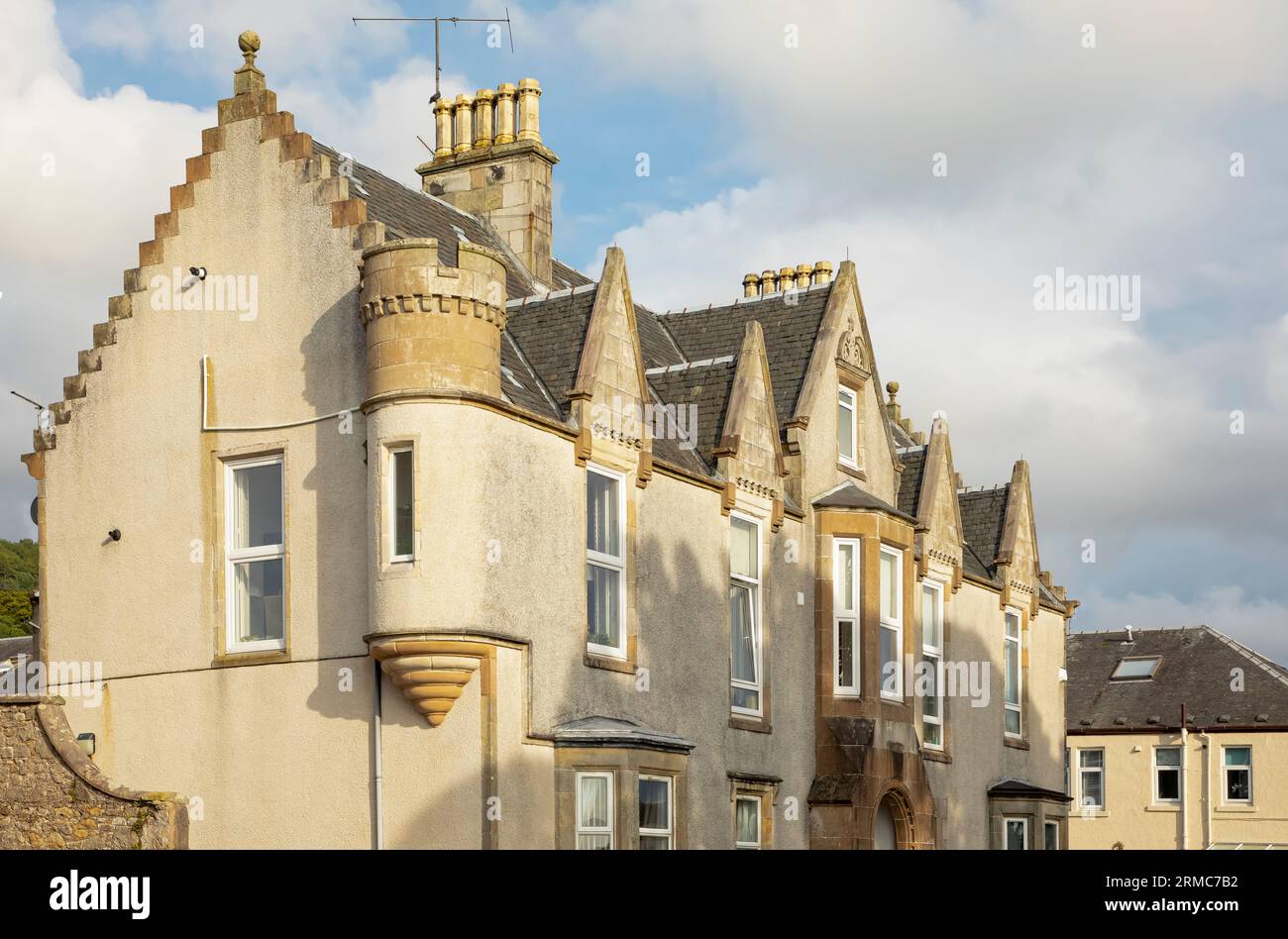 Ornate building with a turret made of pale coloured stone and with lots ...