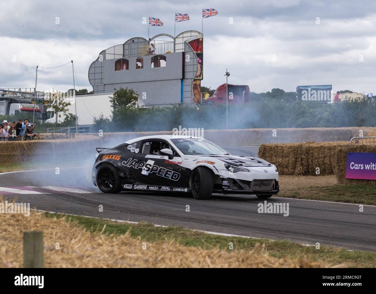 A Raleigh car skids around the race track leaving a plume of tyre smoke ...